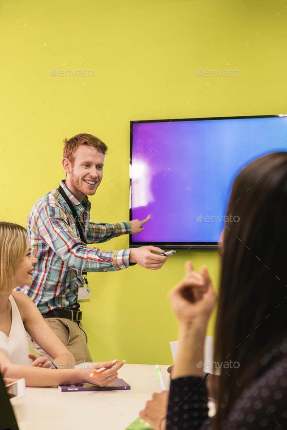 Teacher explaining the lesson to his students. Stock Photo by nunezimage
