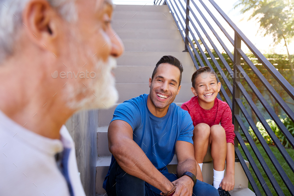 Smiling Multi-Generation Male Hispanic Family Sitting On Steps In ...