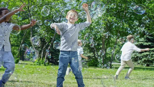 Kids Chasing Bubbles on Green Lawn in Park, Stock Footage | VideoHive