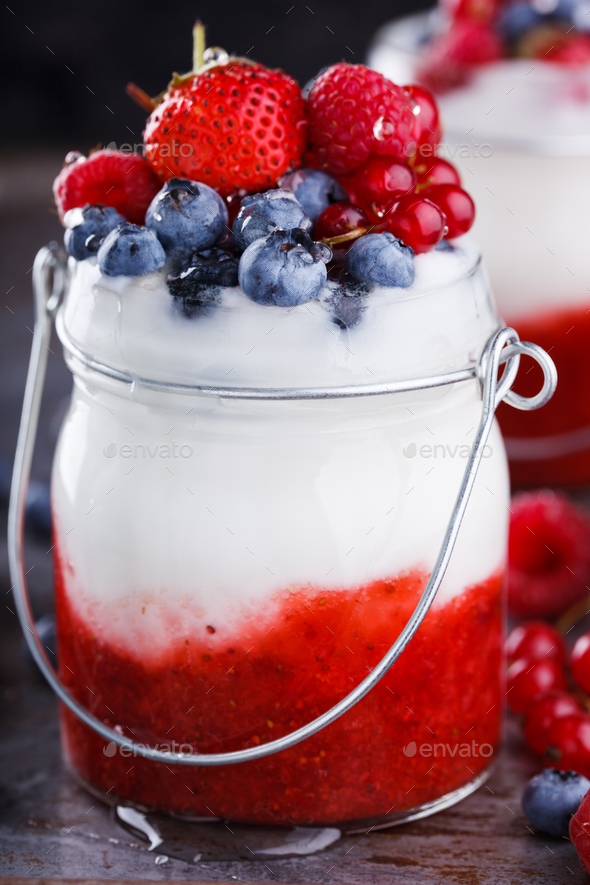Yogurt,homemade,with fresh berries, berry puree in a glass container ...