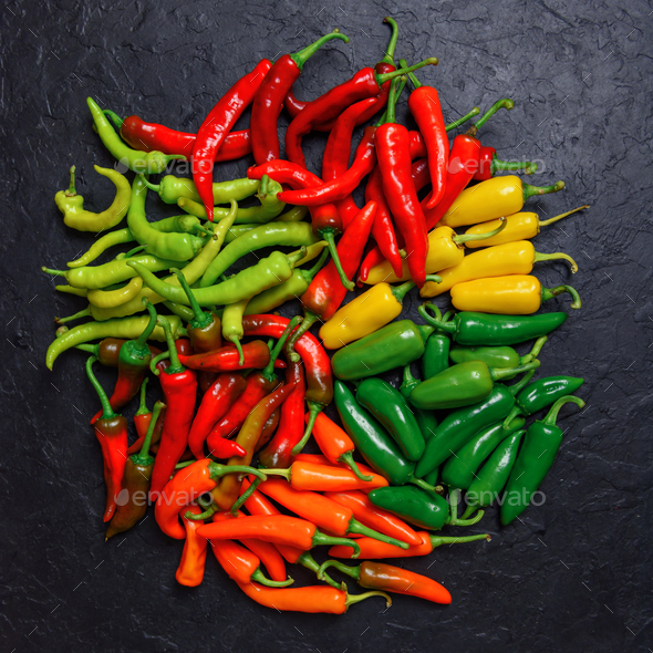 Different colors hot peppers on black background Stock Photo by ivankmit