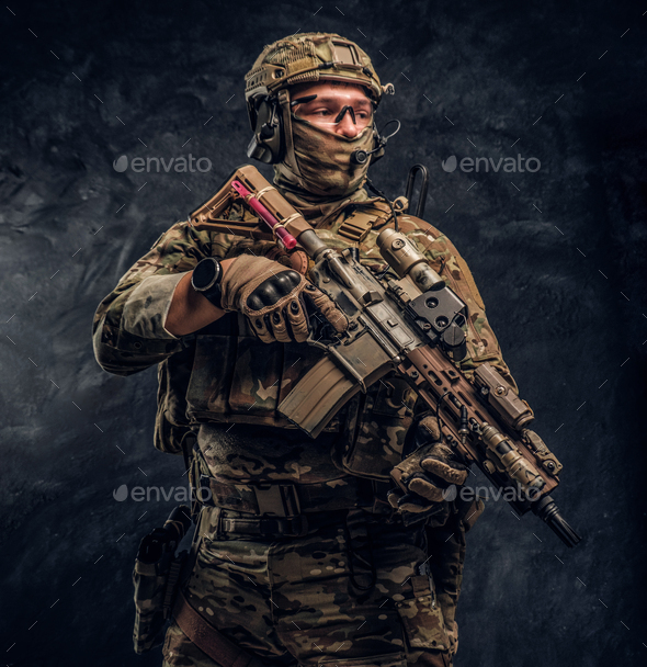 Fully equipped soldier in camouflage uniform holding an assault rifle ...