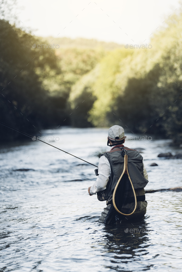 Fly fisherman using flyfishing rod. Stock Photo by nunezimage | PhotoDune