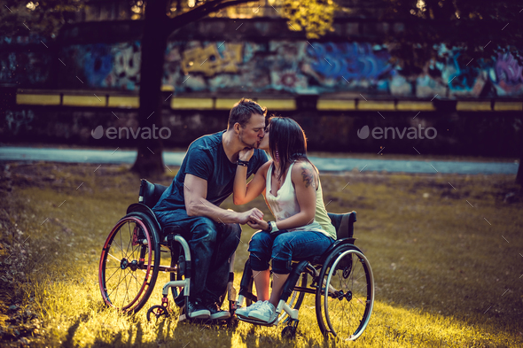 Handicapped young couple on two wheelchairs. Stock Photo by fxquadro