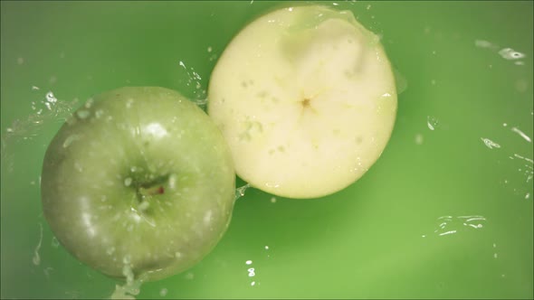 Green Apple Falling on Juice with Splash and Divided in Half, Stock Footage