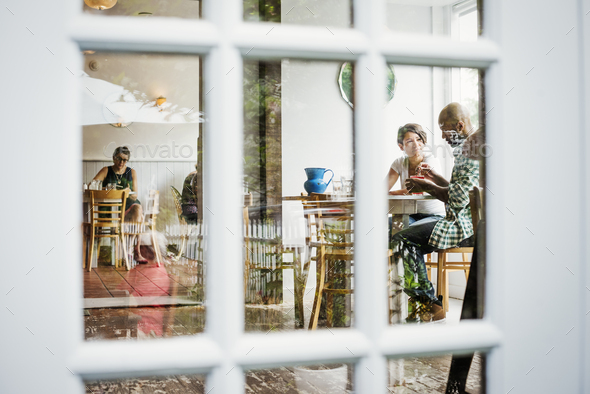 View through a window into a cafe, people sitting at tables. Stock ...