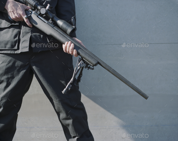 Man in armed forces holding high powered sniper riifle Stock Photo by ...