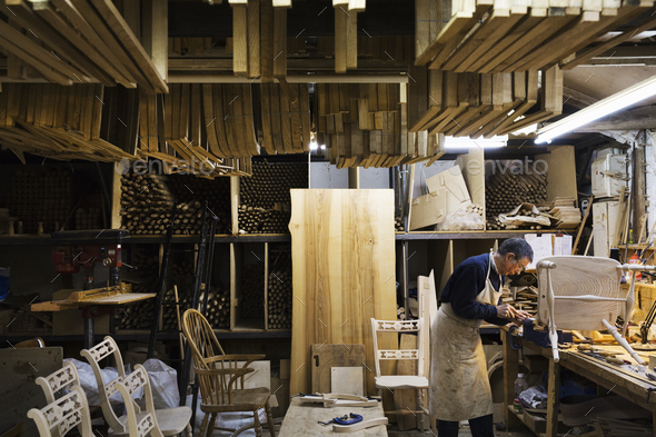 Man standing at a work bench in a carpentry workshop, working on a ...
