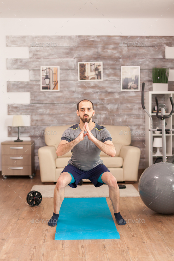 Fit man training his legs on yoga mat Stock Photo by DC_Studio | PhotoDune