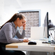 Overworked and frustrated young woman in front of computer in office ...