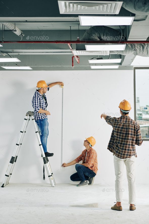 Construction Workers Measuring Length Stock Photo by DragonImages ...