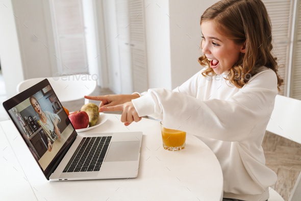 Photo of cheerful girl taking video call and pointing at laptop Stock ...