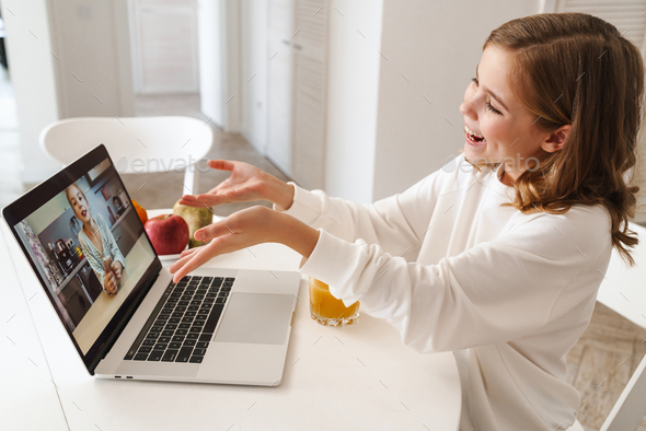 Photo of cheerful girl taking video call on laptop and showing hands ...