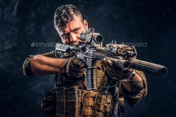 Special forces soldier wearing body armor holding assault rifle and aim ...