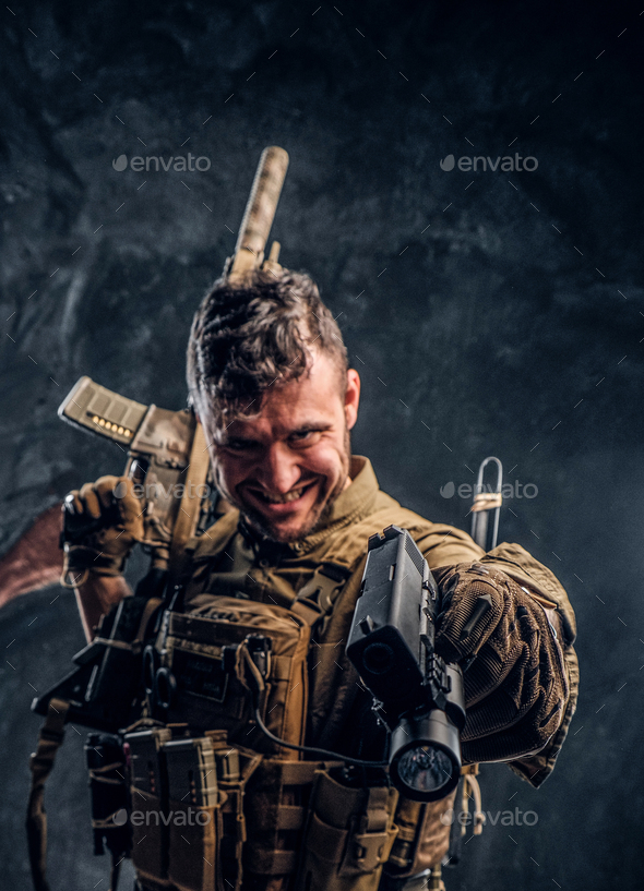 Crazy special forces soldier in body armor holding assault rifle and ...