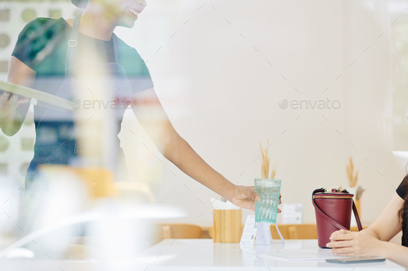 Waiter giving water to customer Stock Photo by DragonImages | PhotoDune