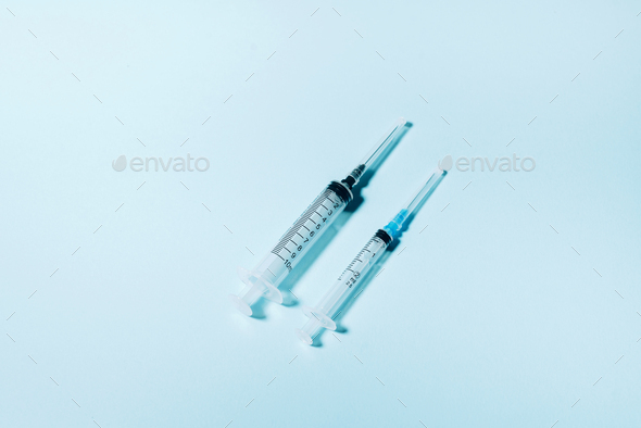 Syringe and needle on blue background. Injections and vaccination ...