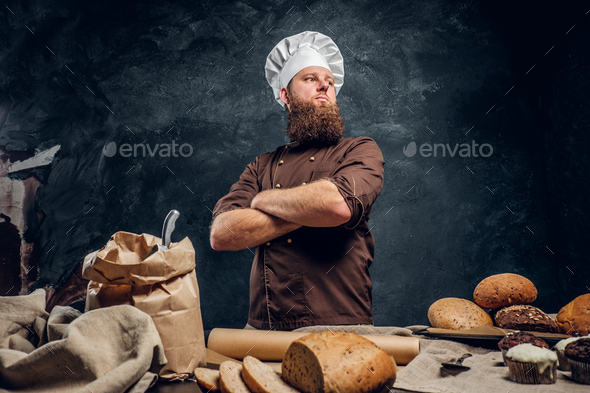 Bearded baker wearing a uniform with decorated with delicious bread ...