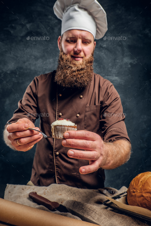 Bearded baker wearing a uniform with decorated with delicious bread ...