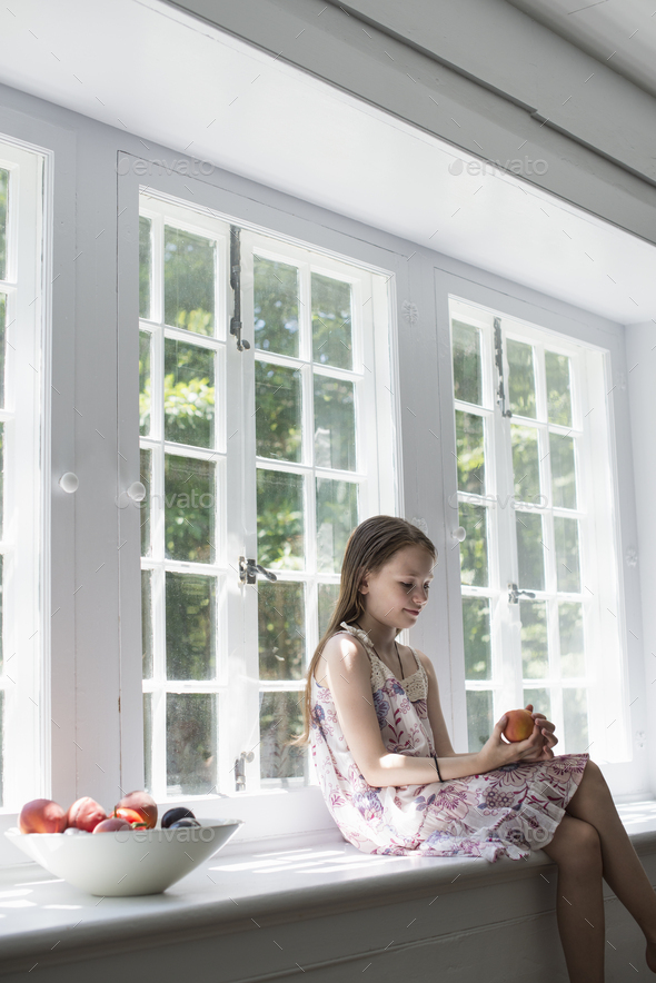 Girl sitting by a window. Stock Photo by Mint_Images | PhotoDune