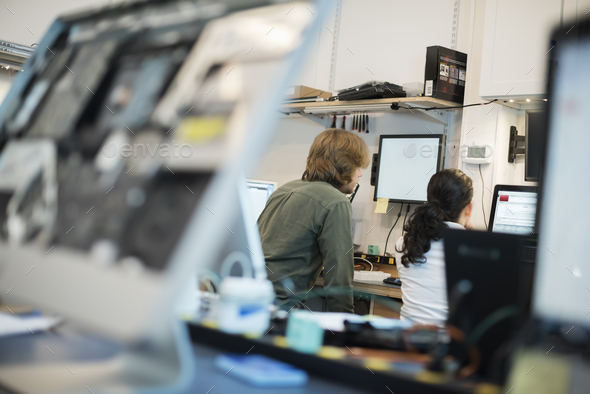 Computer Repair Shop, two people seated testing computer monitors ...