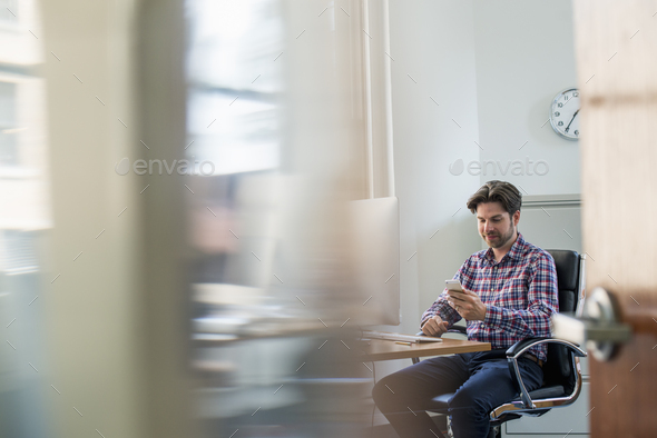 View through an office partition of a man seated at a desk. Stock Photo ...