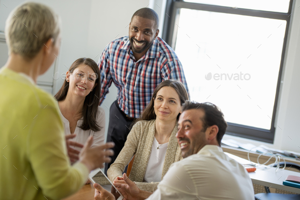 Five people in an office, two men and three women talking. Stock Photo ...