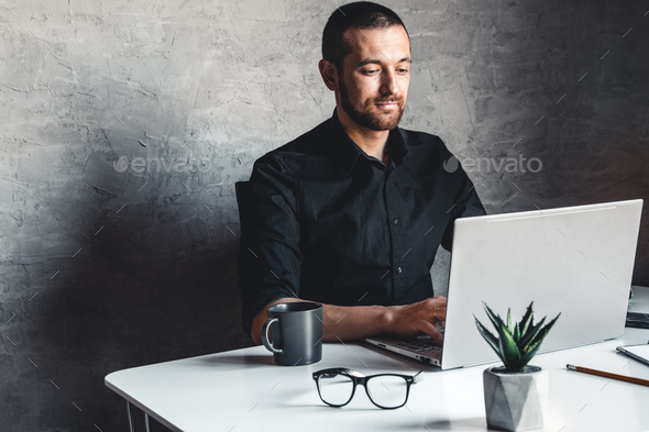 A masked man works at a computer. Pandemic, coronavirus, epidemic Stock ...