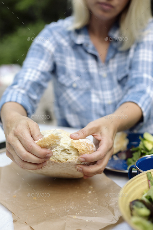 Woman tearing off a piece from a loaf of white bread. Stock Photo by ...