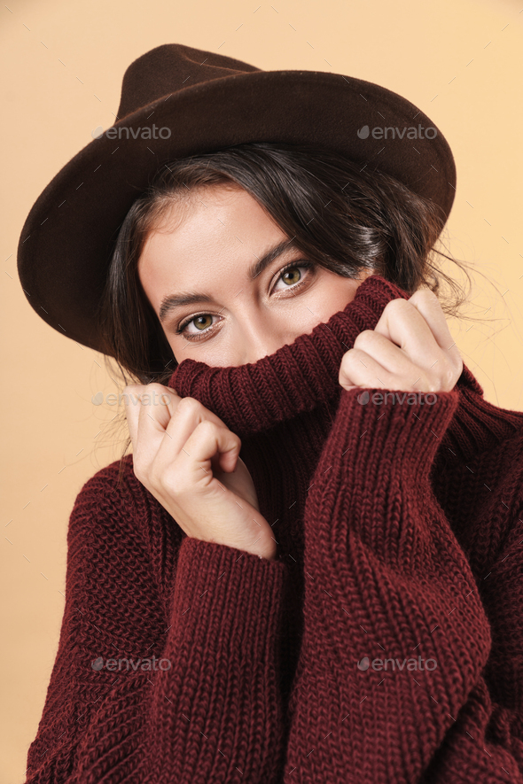 Brunette woman covering face with sweater. Stock Photo by vadymvdrobot