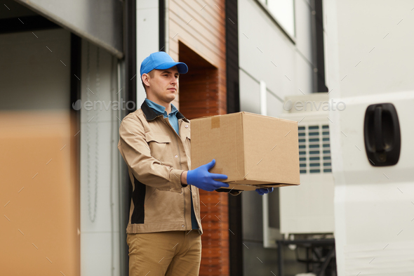 Courier carrying parcel Stock Photo by AnnaStills | PhotoDune