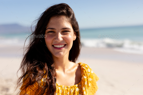 Caucasian woman standing on the beach Stock Photo by Wavebreakmedia