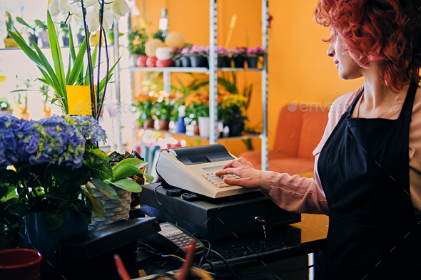 Female flower seller using cash register in a market shop. Stock Photo ...