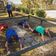 Group of fit women crawling under the net during obstacle course ...