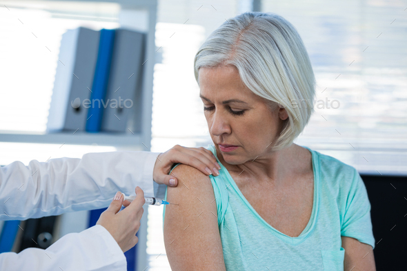 Doctor giving injection to patient Stock Photo by Wavebreakmedia ...