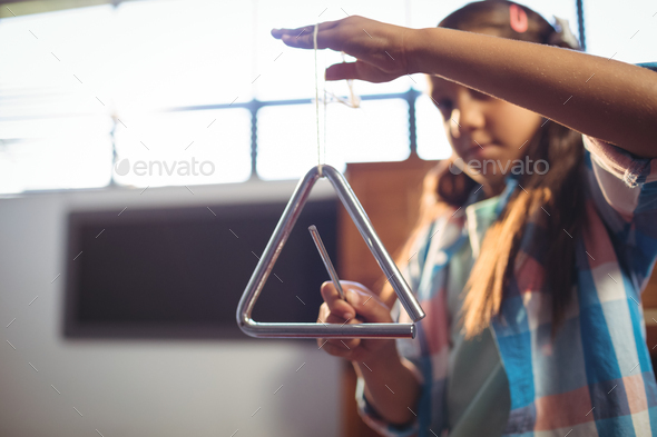 Girl playing triangle in classroom Stock Photo by Wavebreakmedia ...