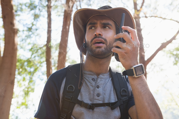 Man using walkie-talkie in the forest Stock Photo by Wavebreakmedia