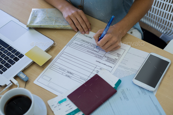 Female executive filling form at her desk Stock Photo by Wavebreakmedia