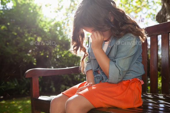 Upset girl crying while sitting on wooden bench Stock Photo by ...