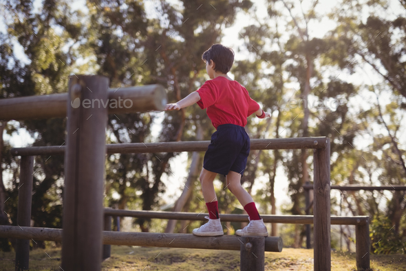 Boy walking on obstacle during obstacle course Stock Photo by ...
