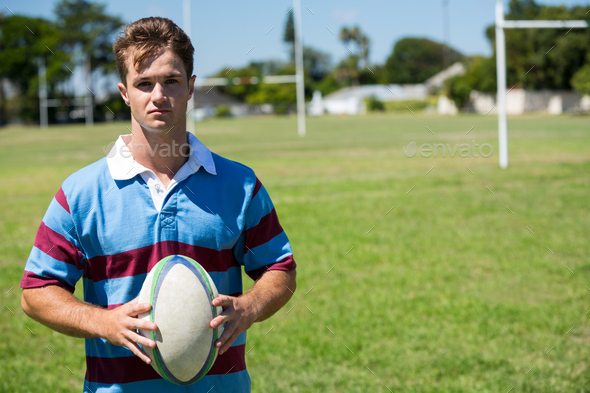 Portrait of rugby player holding ball Stock Photo by Wavebreakmedia