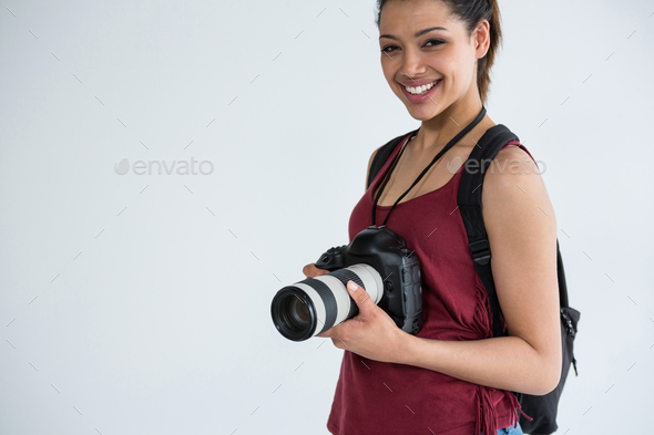 Happy female photographer standing in studio Stock Photo by Wavebreakmedia