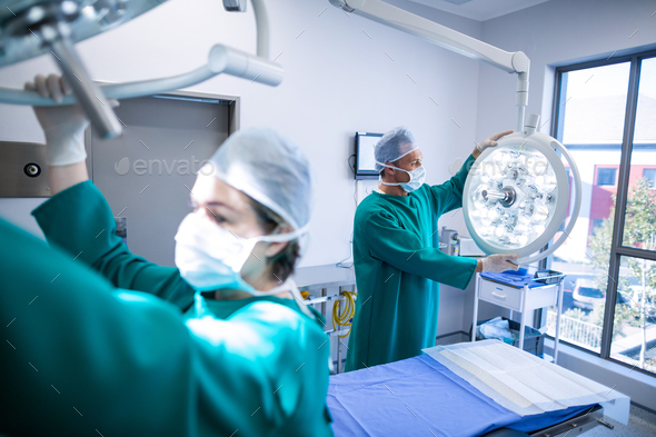 Surgeons adjusting surgical light in operation room Stock Photo by ...