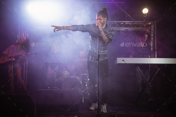 Male singer performing on stage during music festival Stock Photo by ...