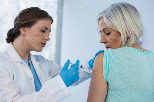Doctor giving injection to patient Stock Photo by Wavebreakmedia ...