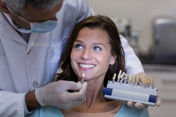 Dentist examining female patient with teeth shades Stock Photo by ...
