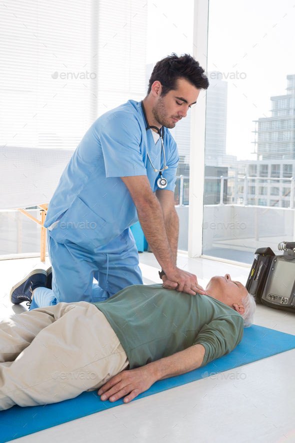 Doctor performing resuscitation on patient Stock Photo by Wavebreakmedia