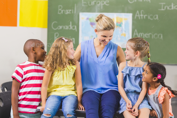 Teacher and kids having fun in classroom Stock Photo by Wavebreakmedia
