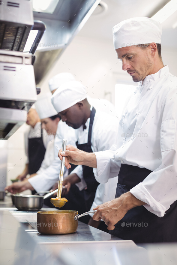 Team of chef preparing food in the commercial kitchen Stock Photo by ...