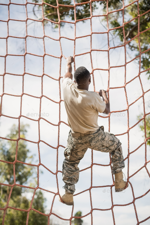 Military soldier climbing net during obstacle course Stock Photo by ...